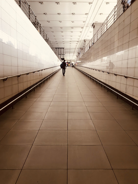 Free: Photo of Person Wearing Backpack Walking in Hallway - nohat.cc