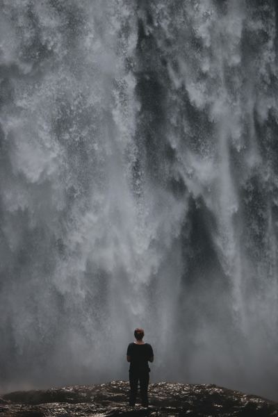 Free: woman standing in front of waterfalls during daytime - nohat.cc