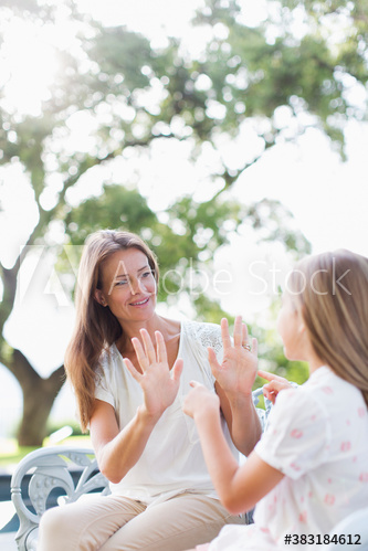 Free: Mother and daughter playing clapping game in sunny park - nohat.cc