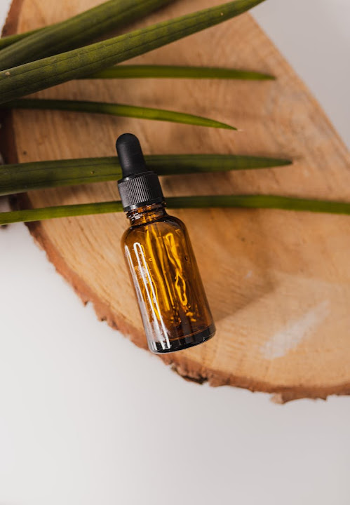 Free: Small essential oil bottle on decorative tree trunk - nohat.cc